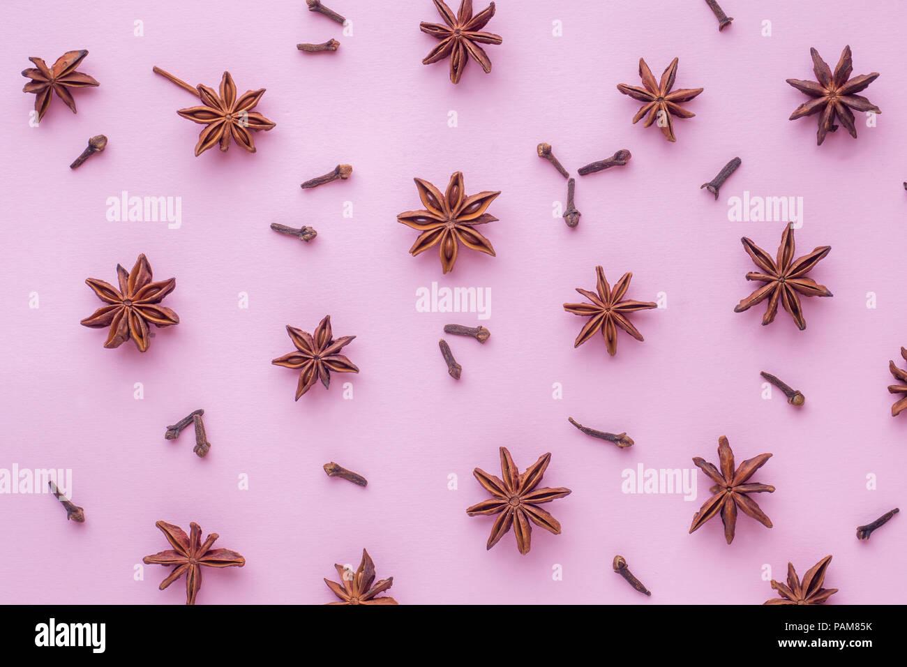 Composition of star anise and cloves on pink background. Abstract flat ...