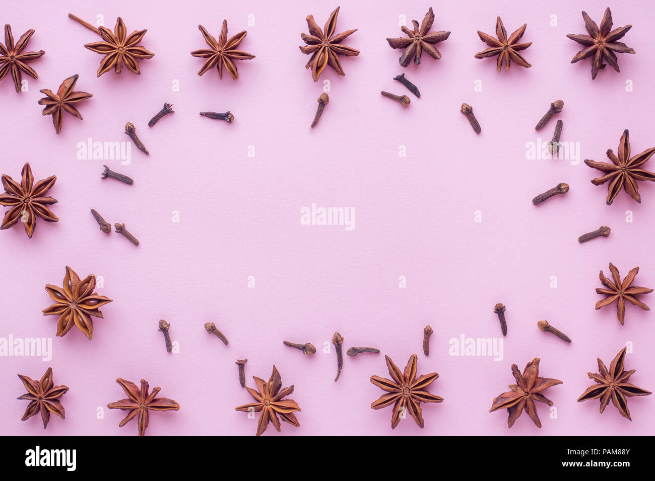 Composition of star anise and cloves on pink background. Abstract flat ...