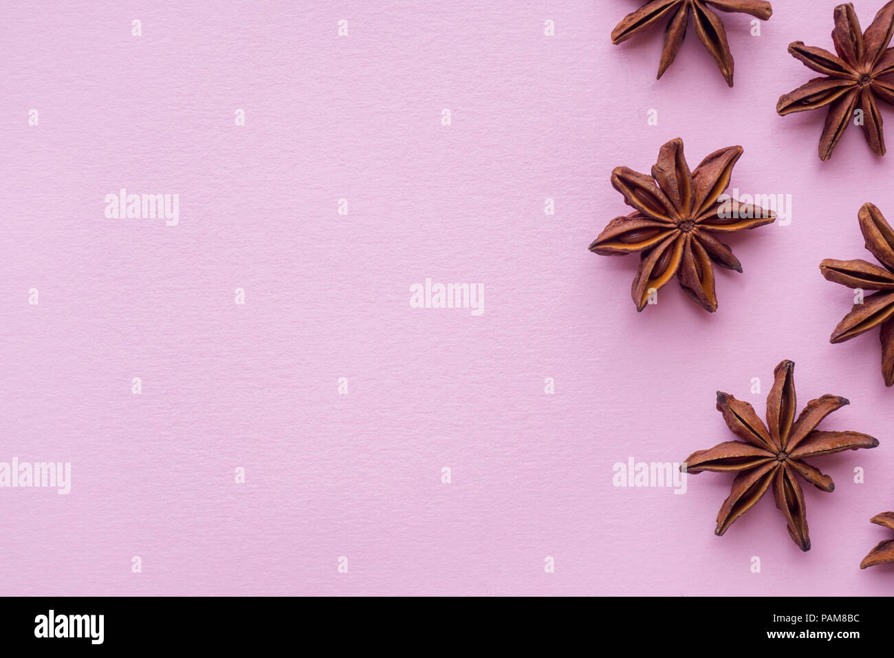 Composition of star anise and cloves on pink background. Abstract flat ...