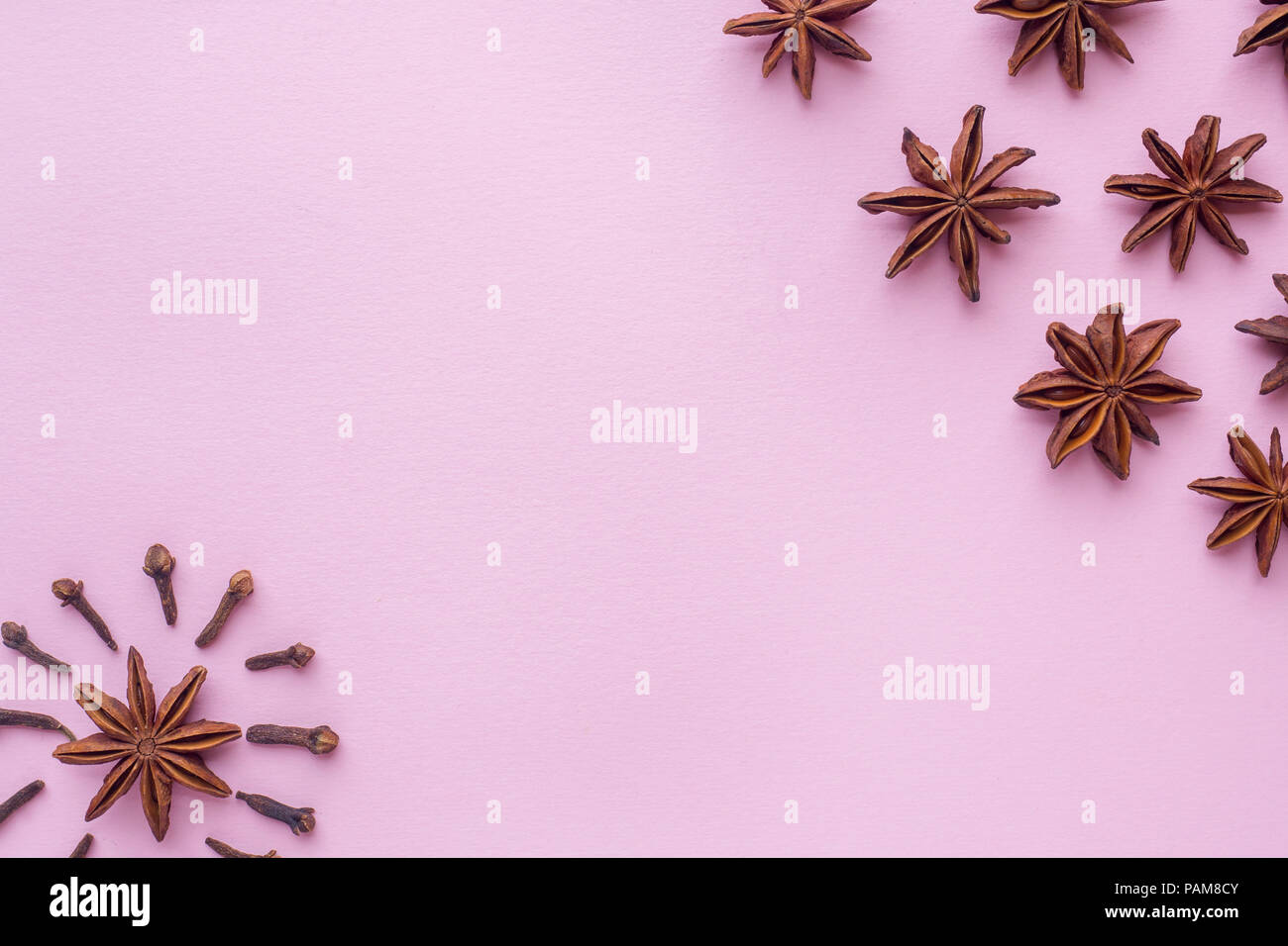Composition of star anise and cloves on pink background. Abstract flat ...