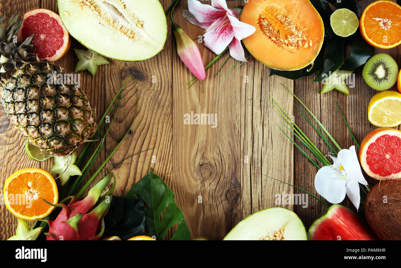 Tropical fruit. Assortment of tropical fruits with leaves of palm trees ...