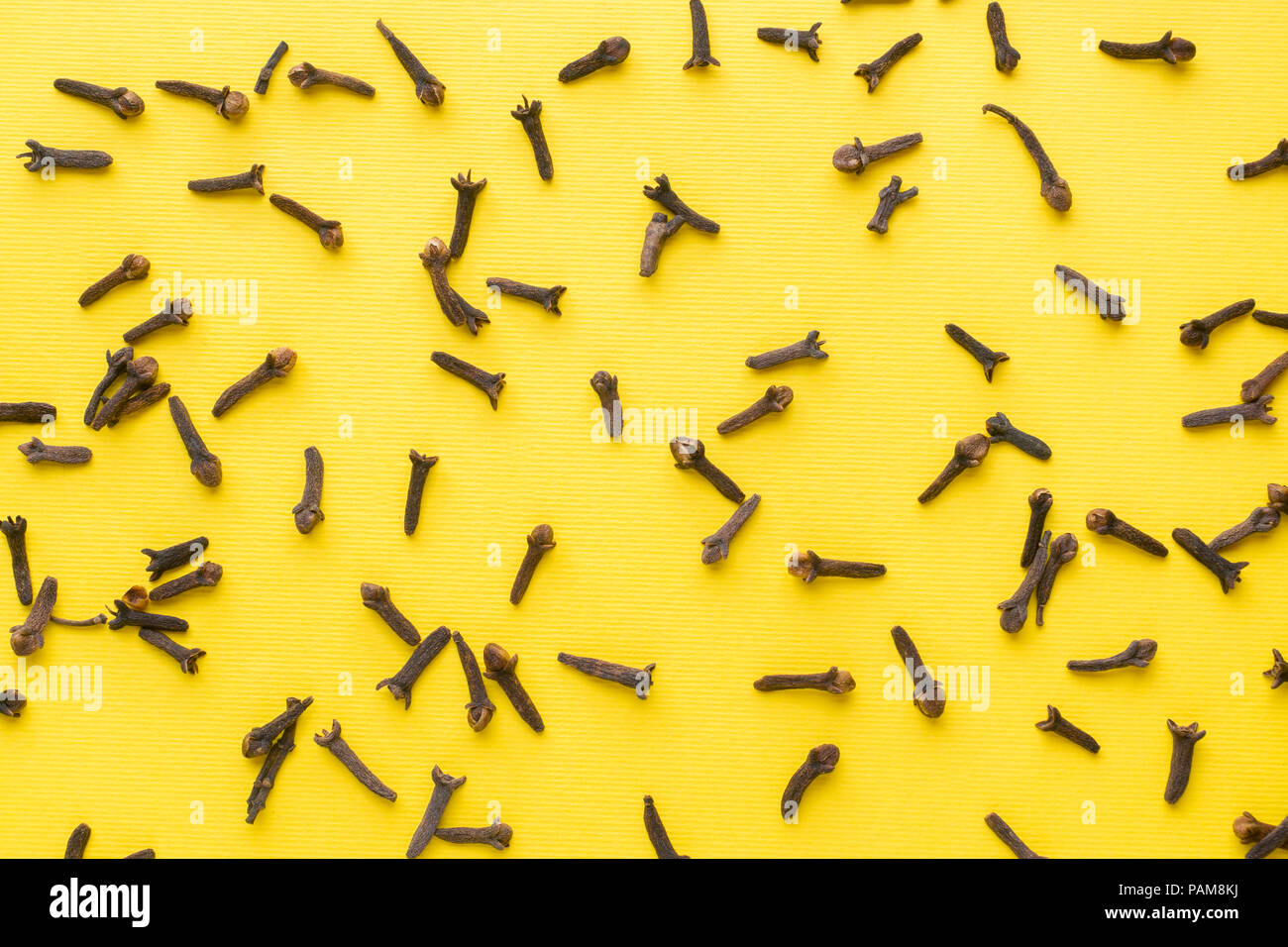 Spices dried cloves on a yellow background. Abstract flat pattern, top ...