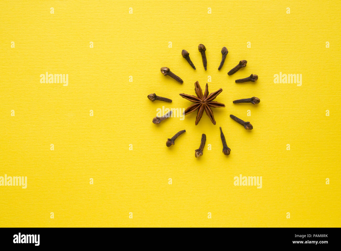 composition of star anise and cloves on a yellow background. Abstract ...