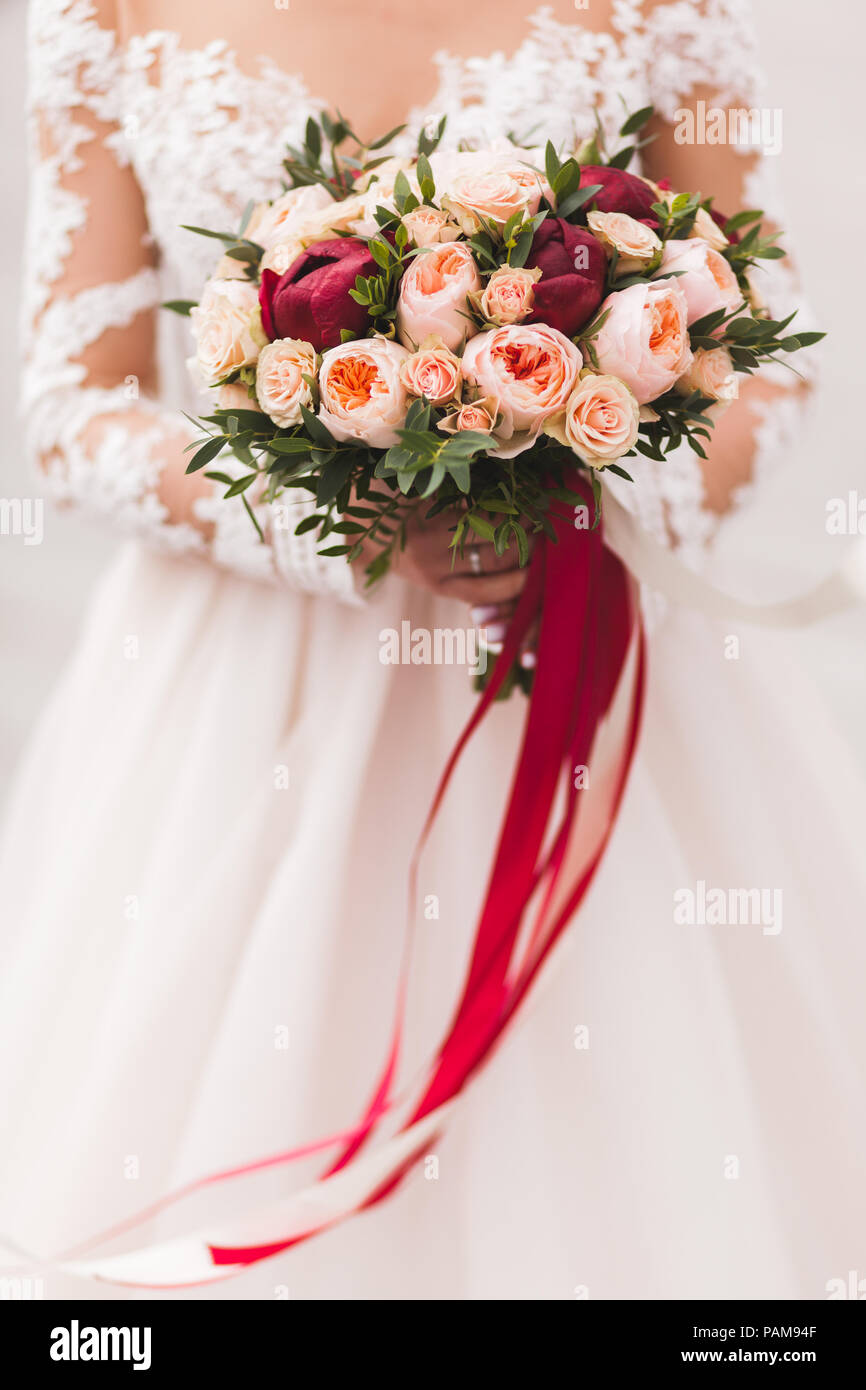 Bride holding in hands beautiful bouquet of flowers in classic style ...