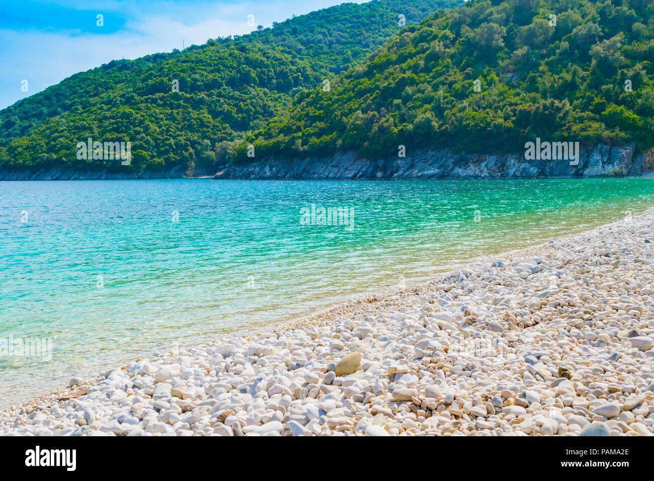 Crystal clear turquoise sea waters of a pebble beach. Poros beach in ...