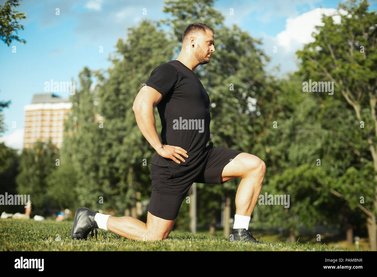 Young attractive man stretching legs outdoors doing forward lunge Man ...