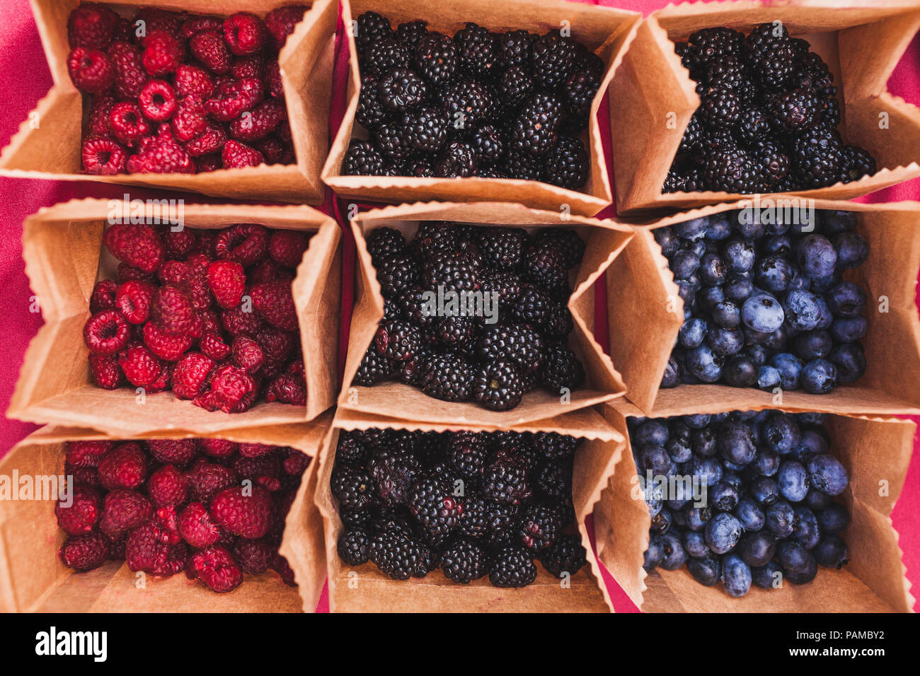 Set of different fresh berries in small craft paper boxes on wedding ...