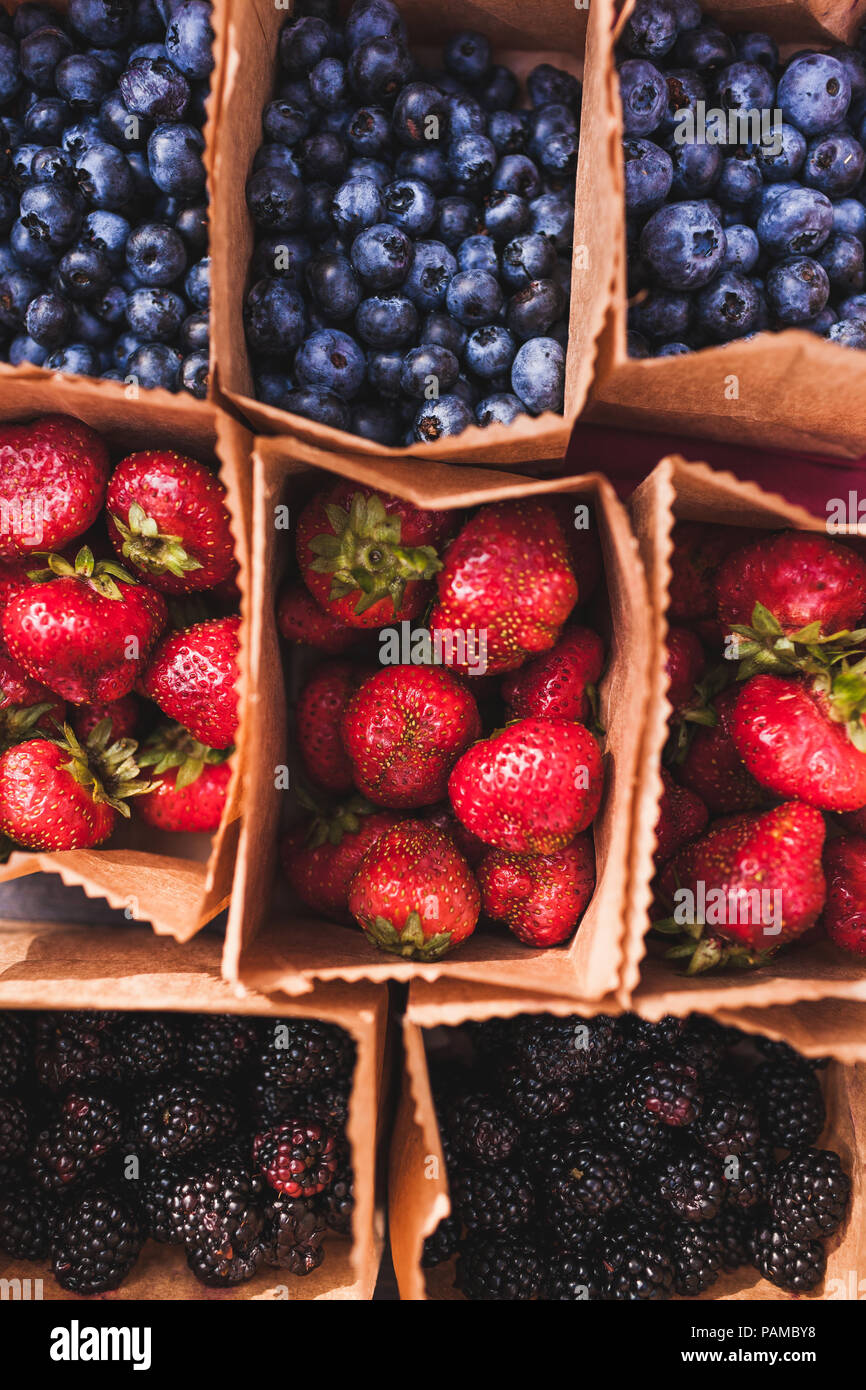 Set of different fresh berries in small craft paper boxes on wedding ...