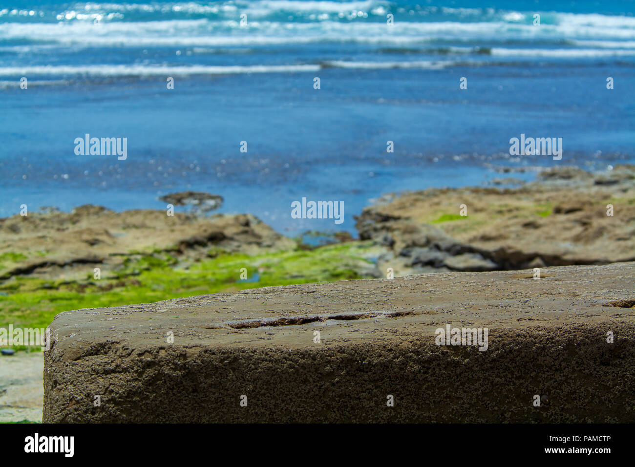 perfect straight rock like a bench in front of a blue ocean Stock Photo ...