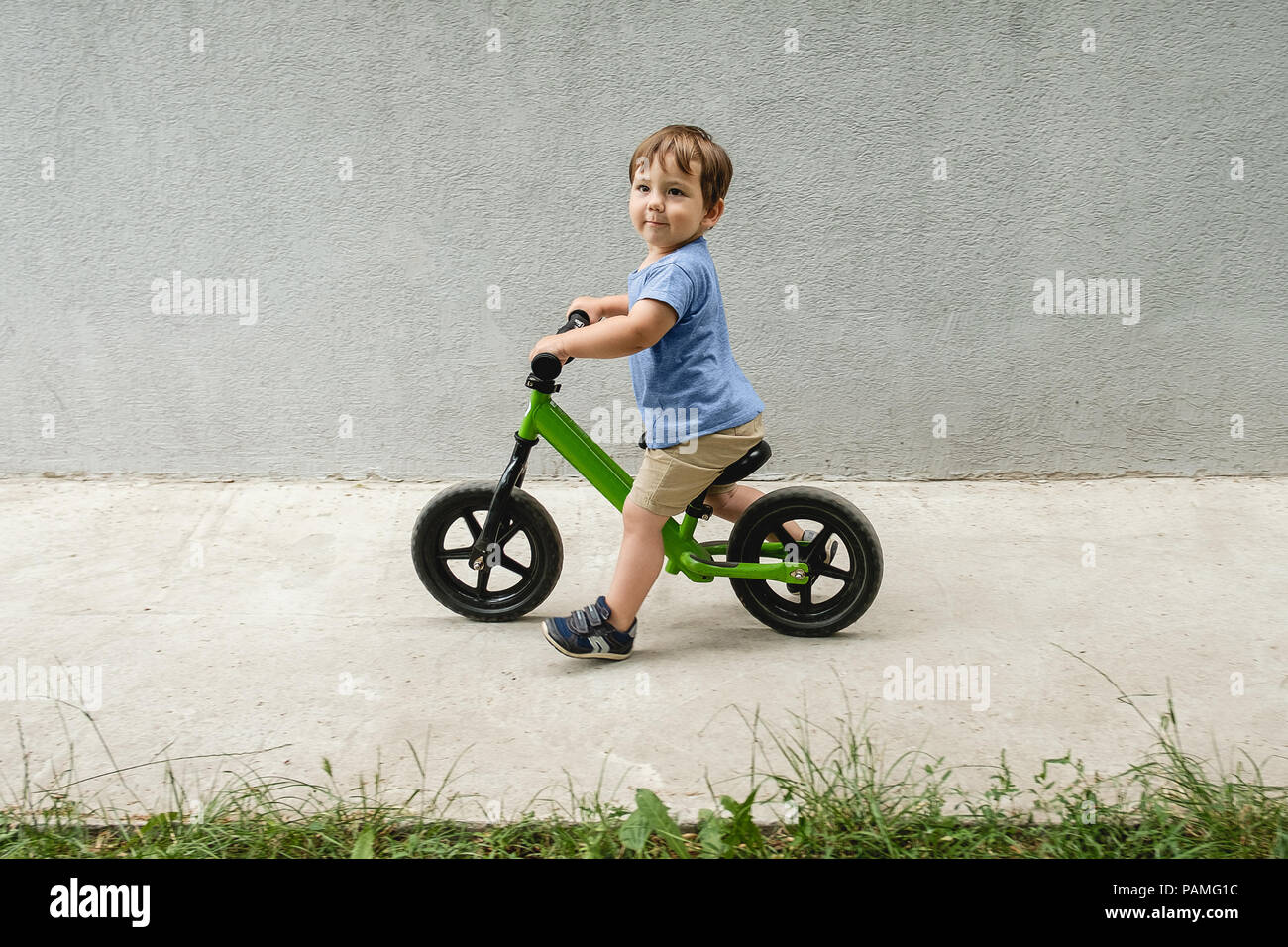 Happy boy riding a small bicycle in the park Stock Photo - Alamy