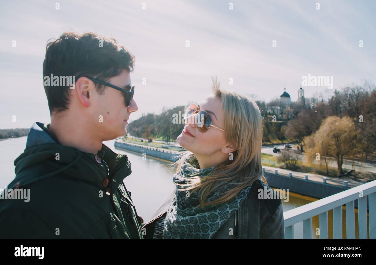 Beautiful loving each other couple is standing on the bridge smiling ...
