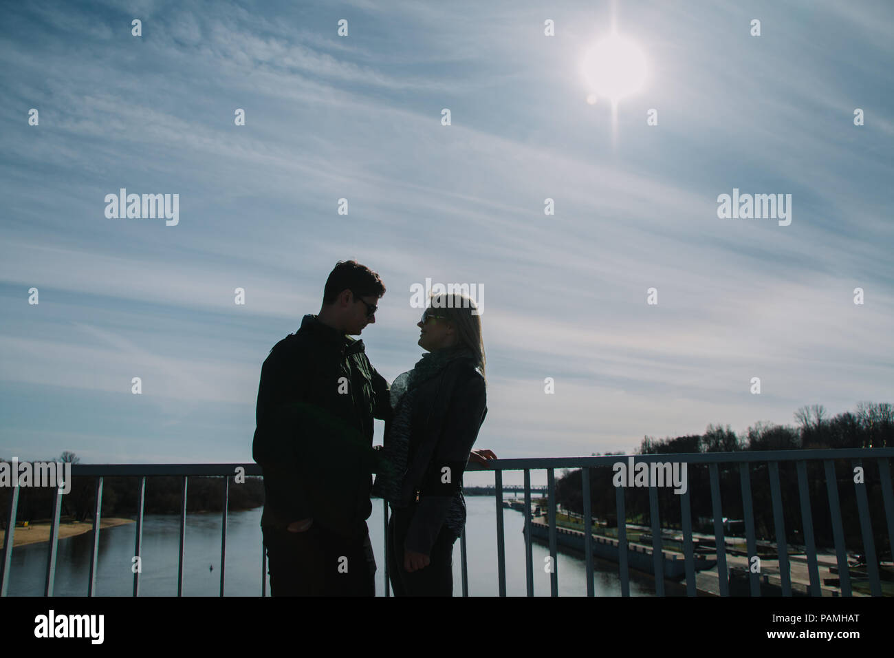 Beautiful loving each other couple is standing on the bridge smiling ...