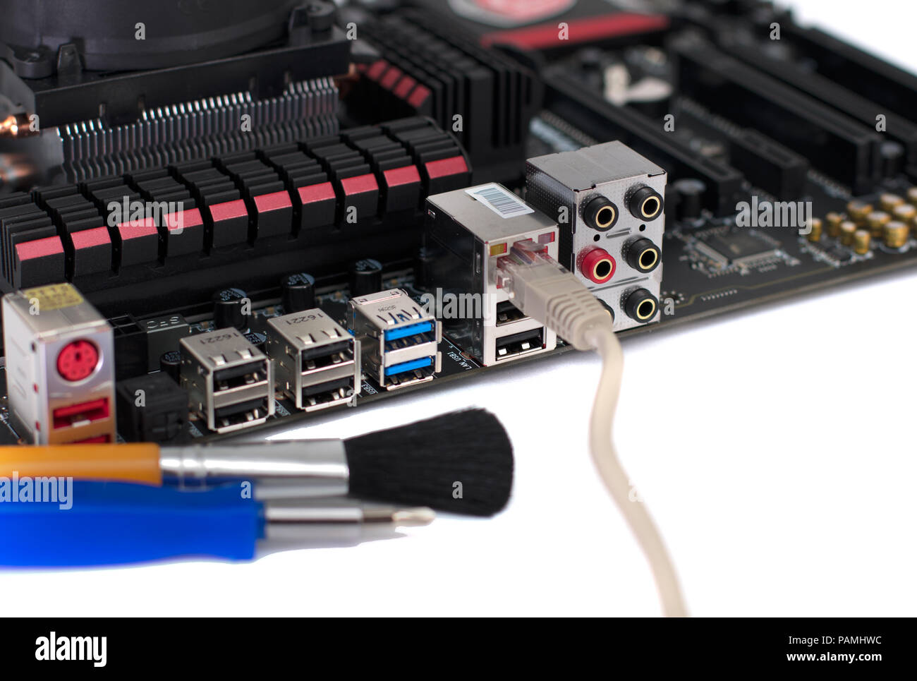 Motherboard with a network cable connected to it and tools for repair ...