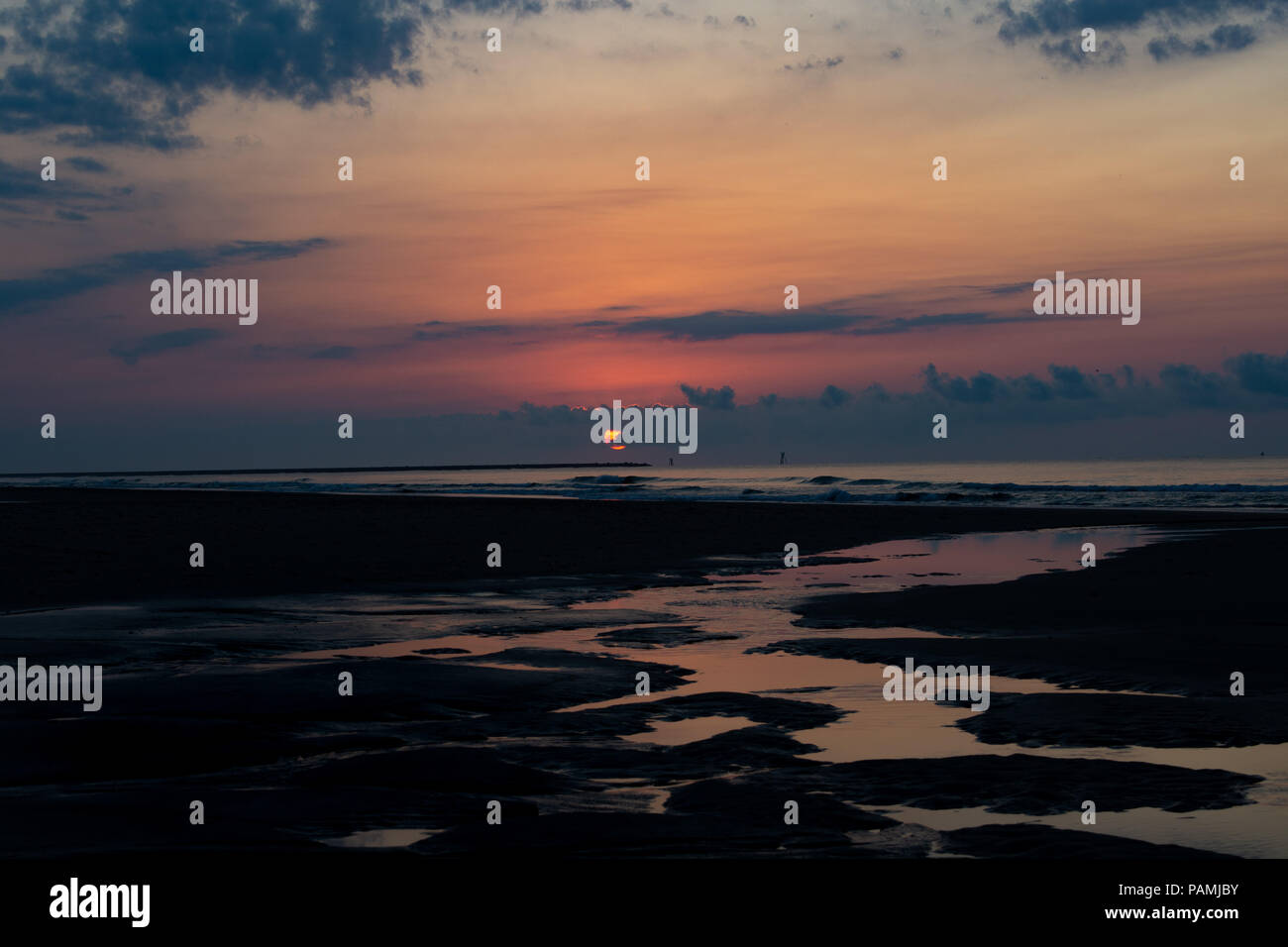 Sunrise reflected off of a tide pool Stock Photo - Alamy