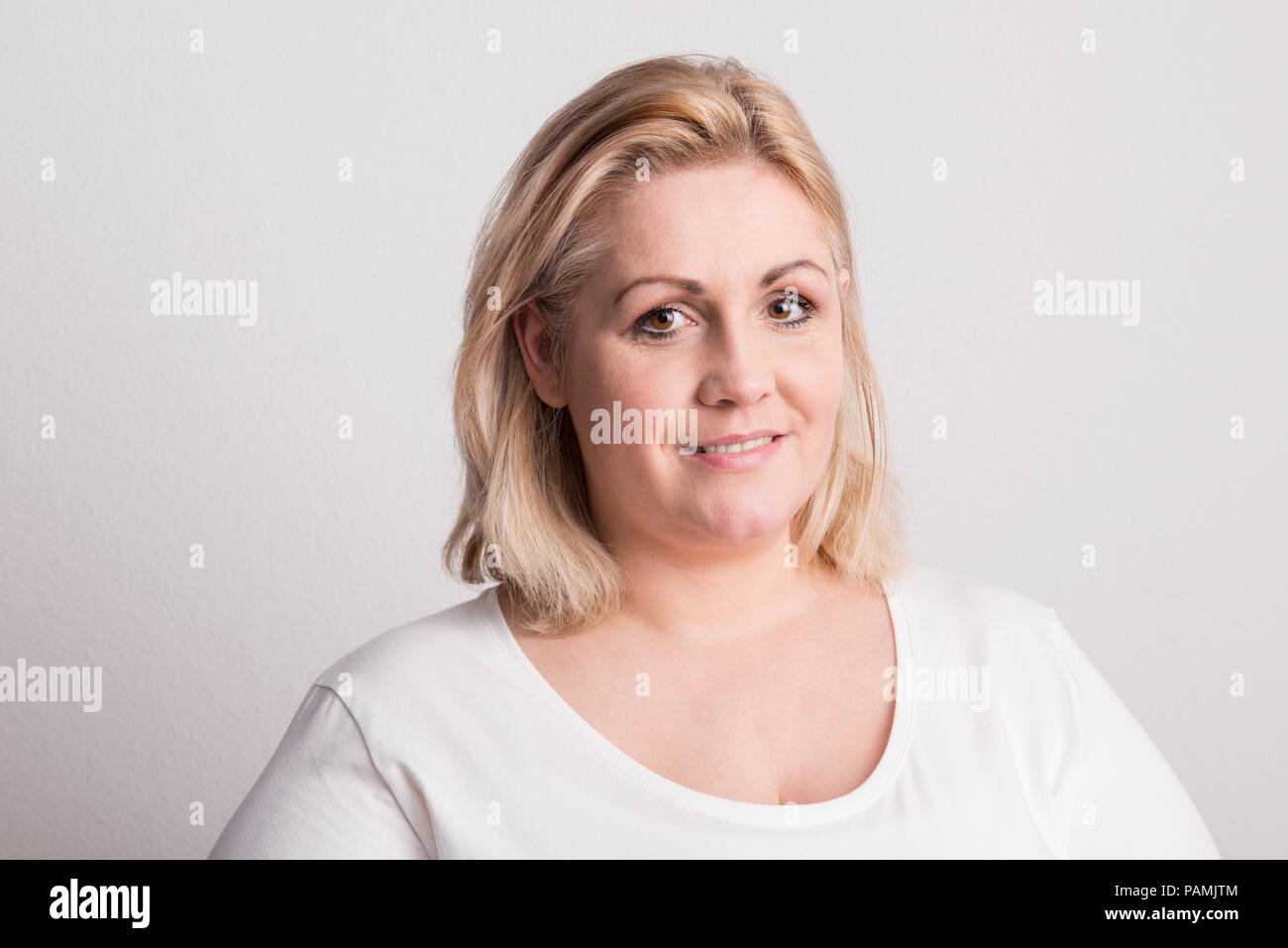 Portrait of an attractive overweight woman in studio on a white ...