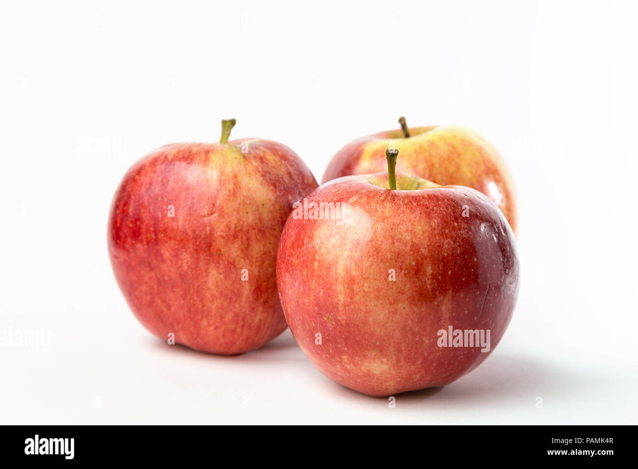 three red apples on white background Stock Photo - Alamy