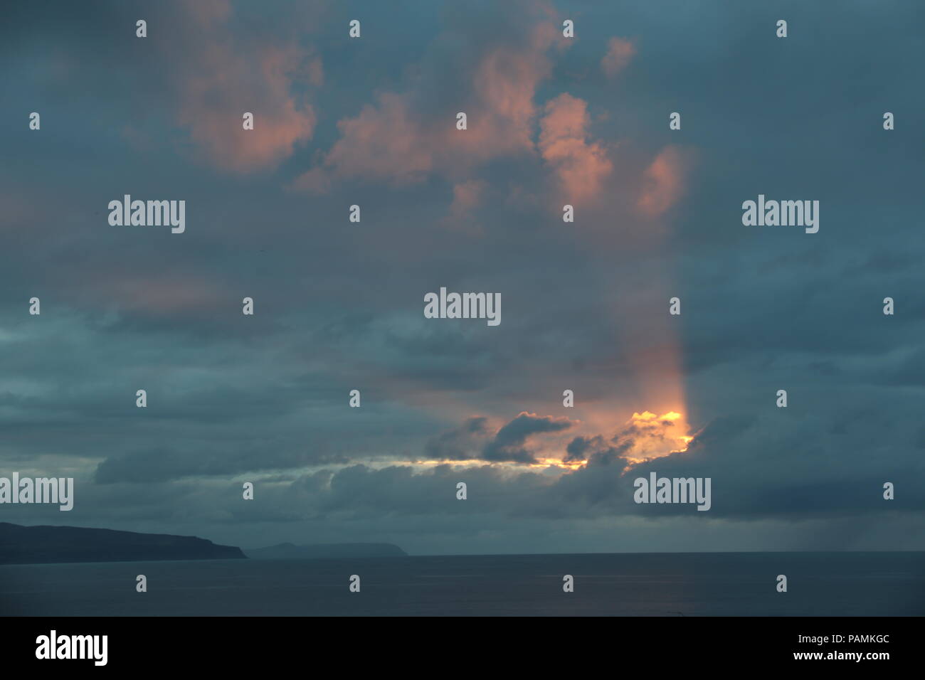 Sunset through clouds Stock Photo - Alamy