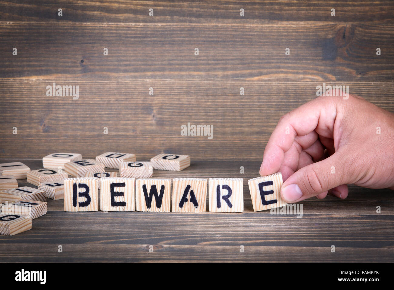 Beware. Wooden letters on the office desk Stock Photo - Alamy