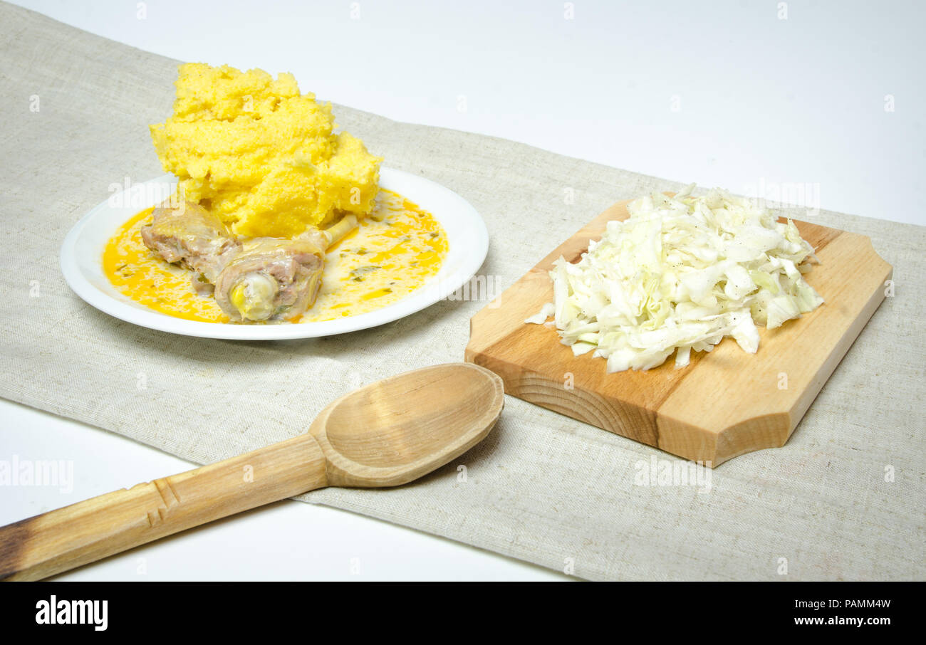 Traditional polenta with lamb stew and cabbage on a wood board Stock ...