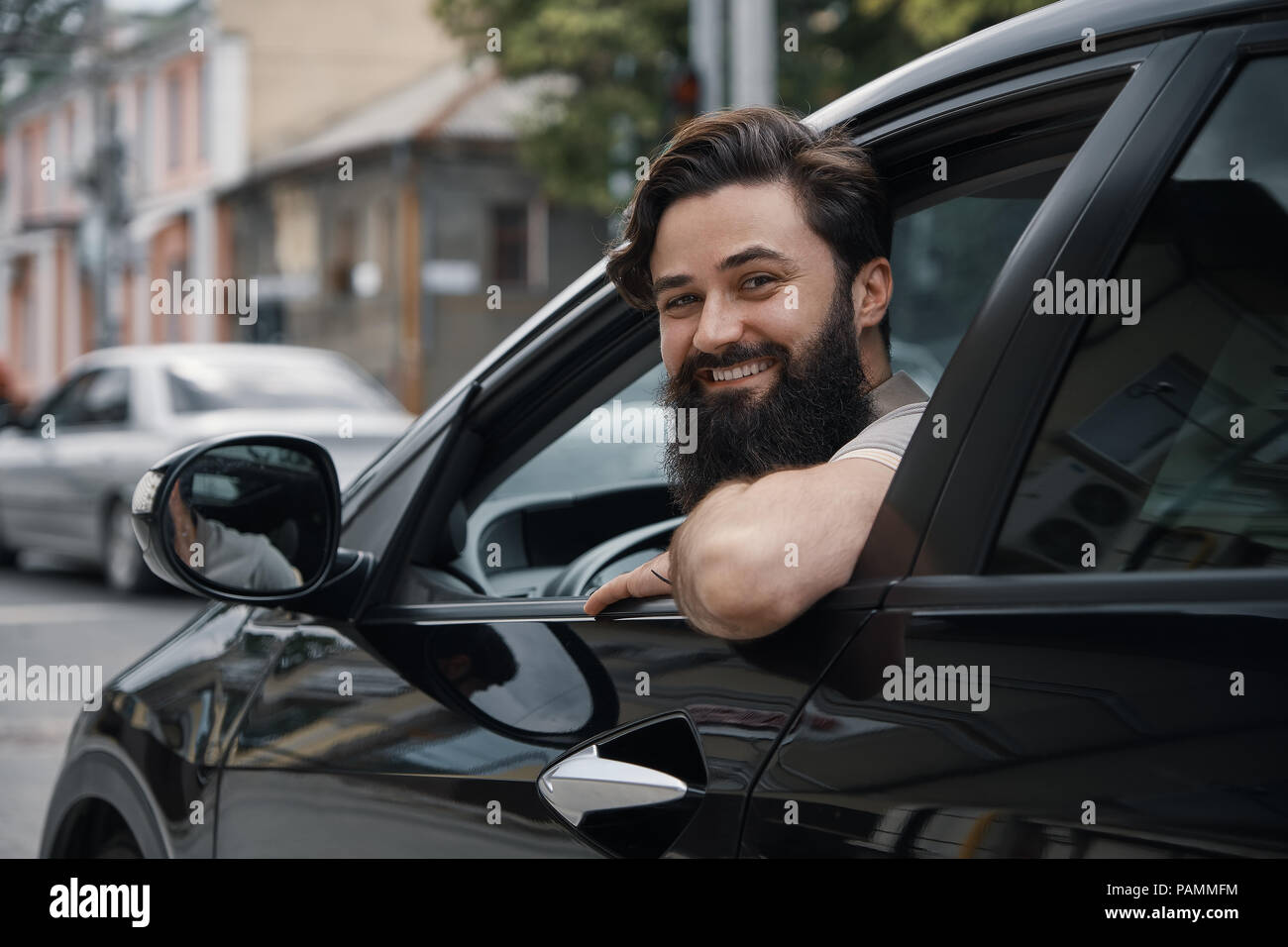 Young man smiling while driving a car Stock Photo - Alamy