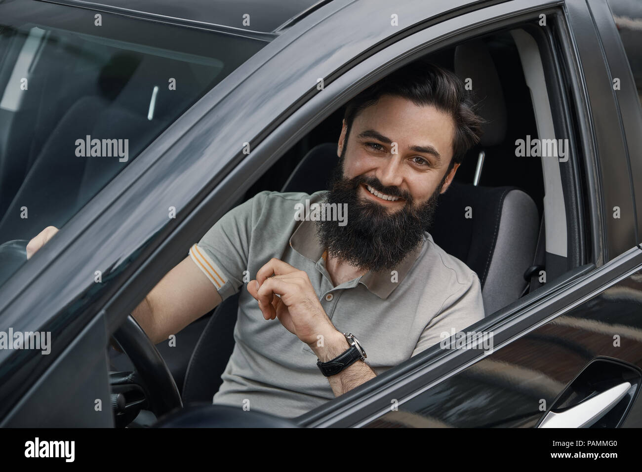 Young man smiling while driving a car Stock Photo - Alamy