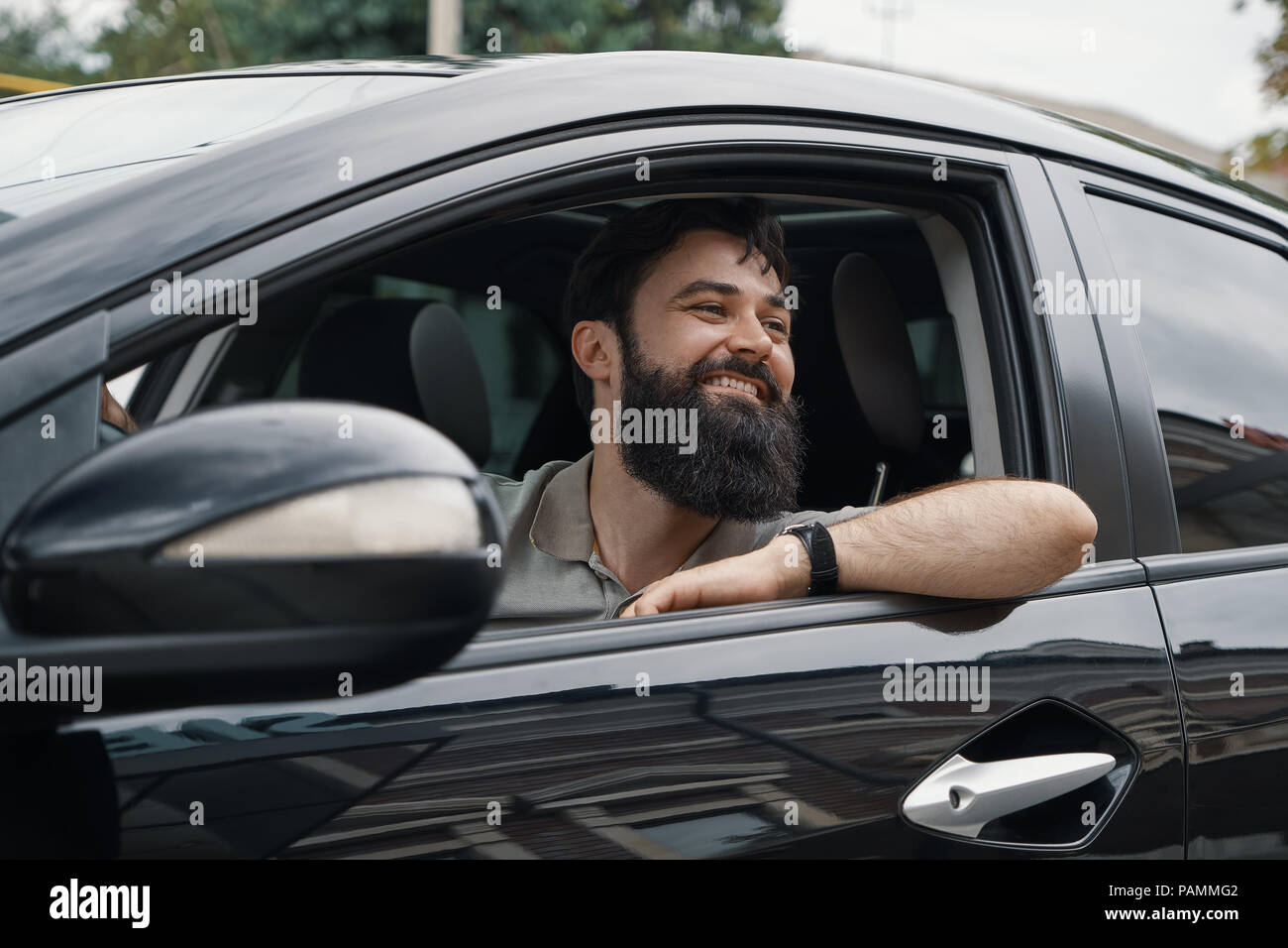 Young man smiling while driving a car Stock Photo - Alamy