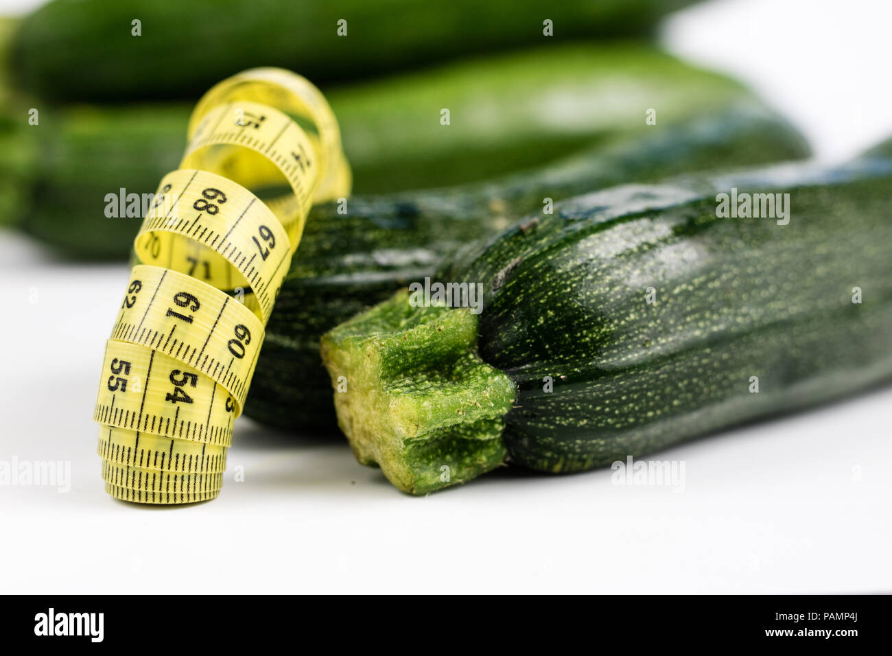 Zucchini on a white table. Tailor measure to measure the waist ...