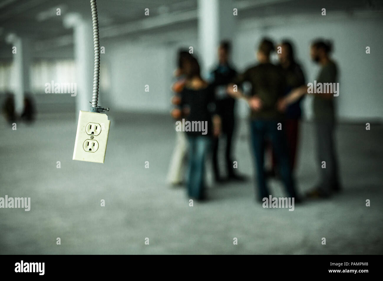 Industrial-grade power outlet floating around, with a blurry group of ...