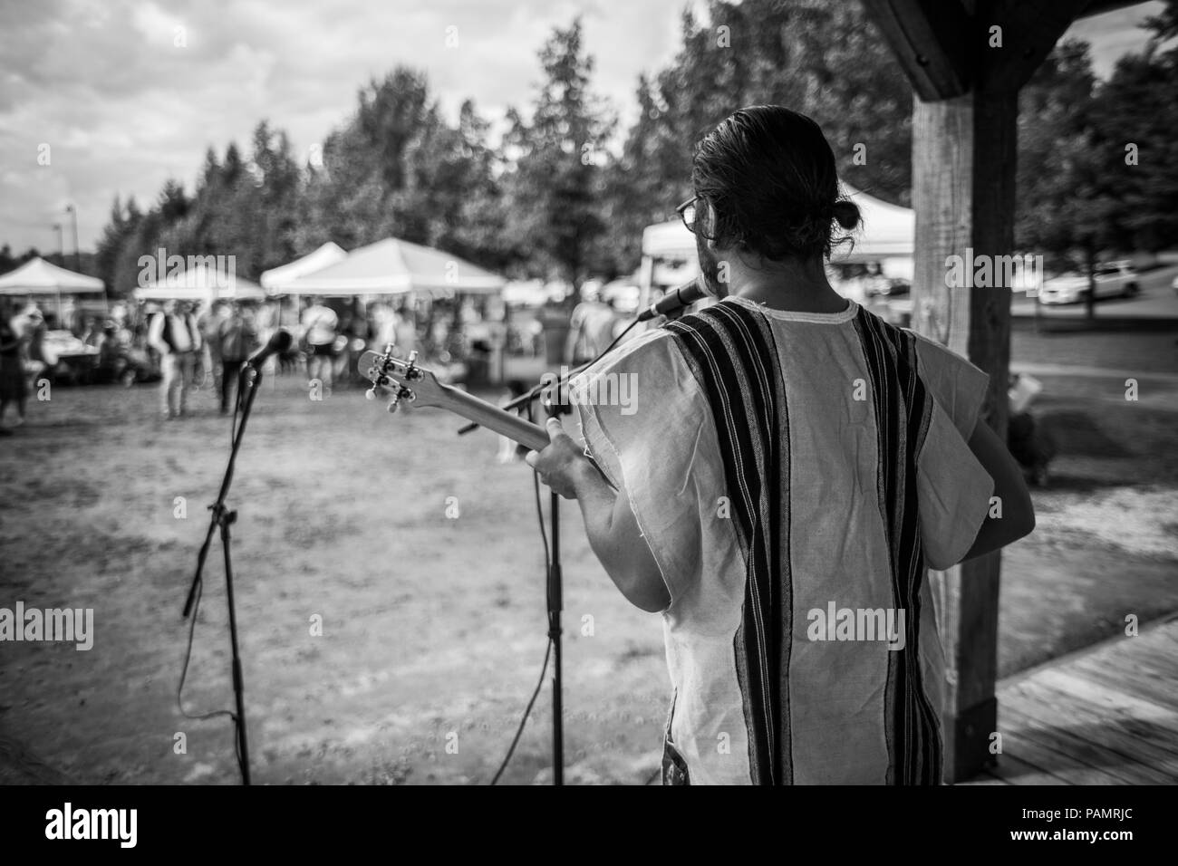 Musician man singing and playing on a stage in front of people and ...