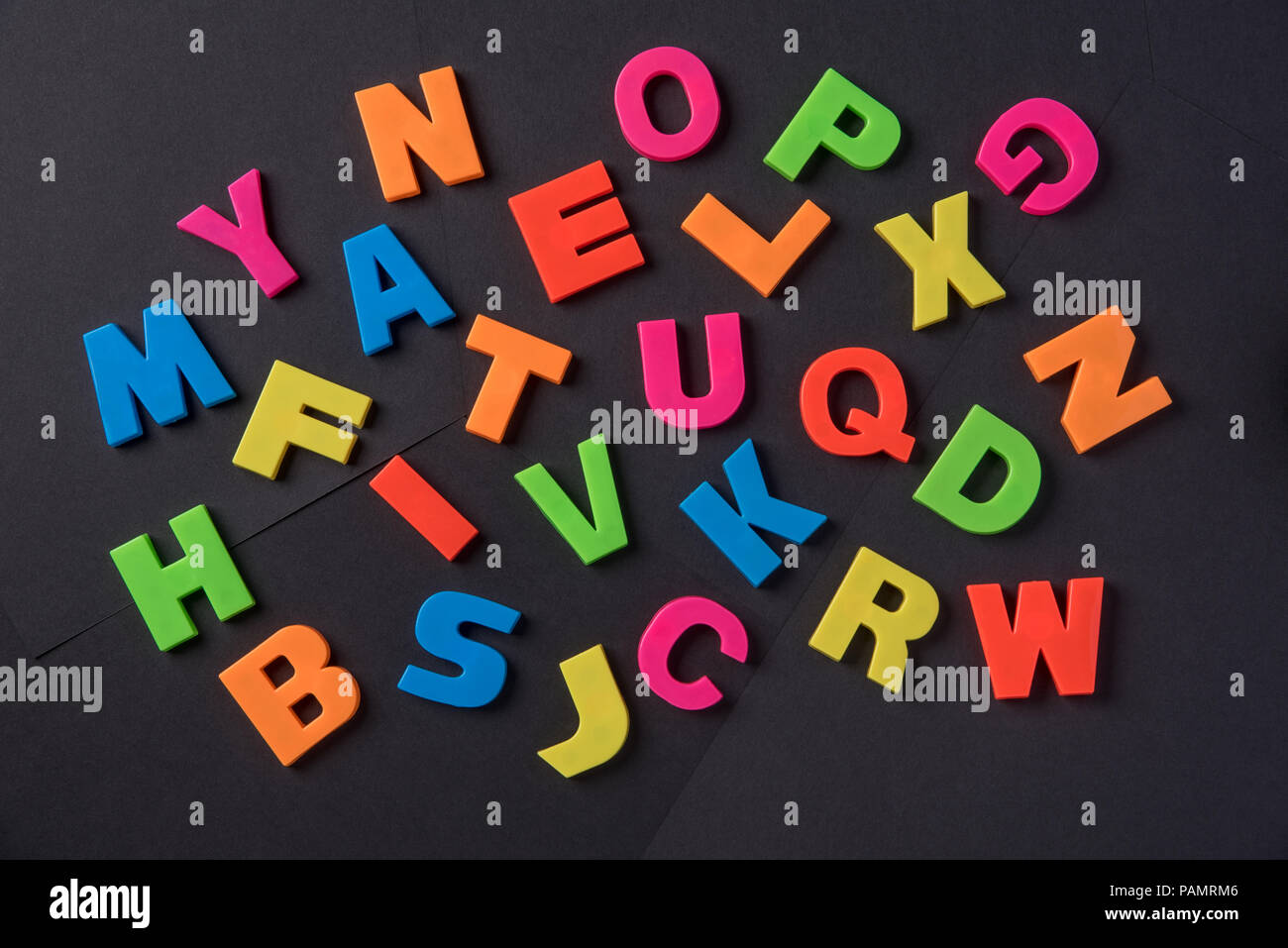 English alphabet of plastic letters of different colors on a black ...