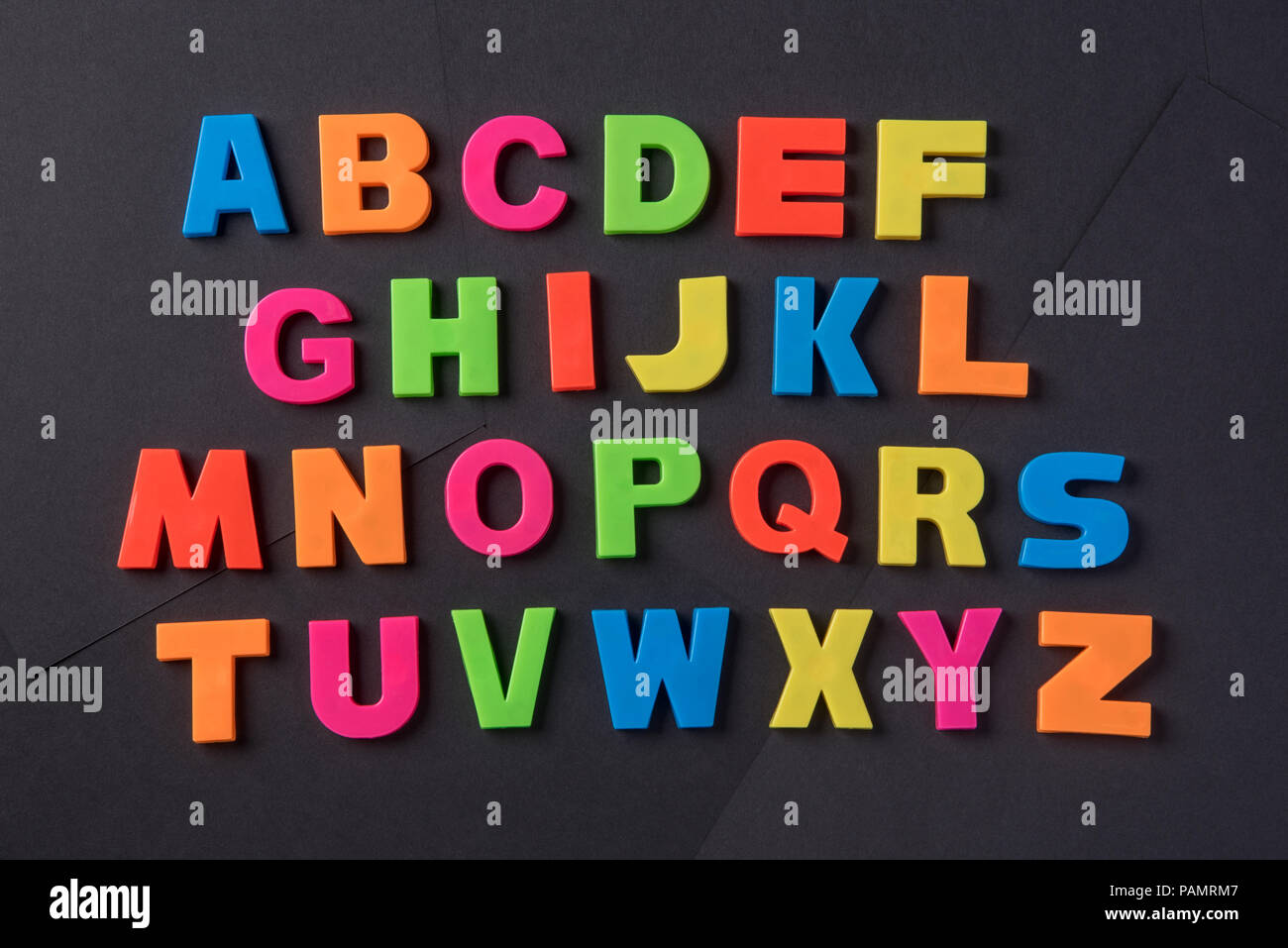 English alphabet of plastic letters of different colors on a black ...
