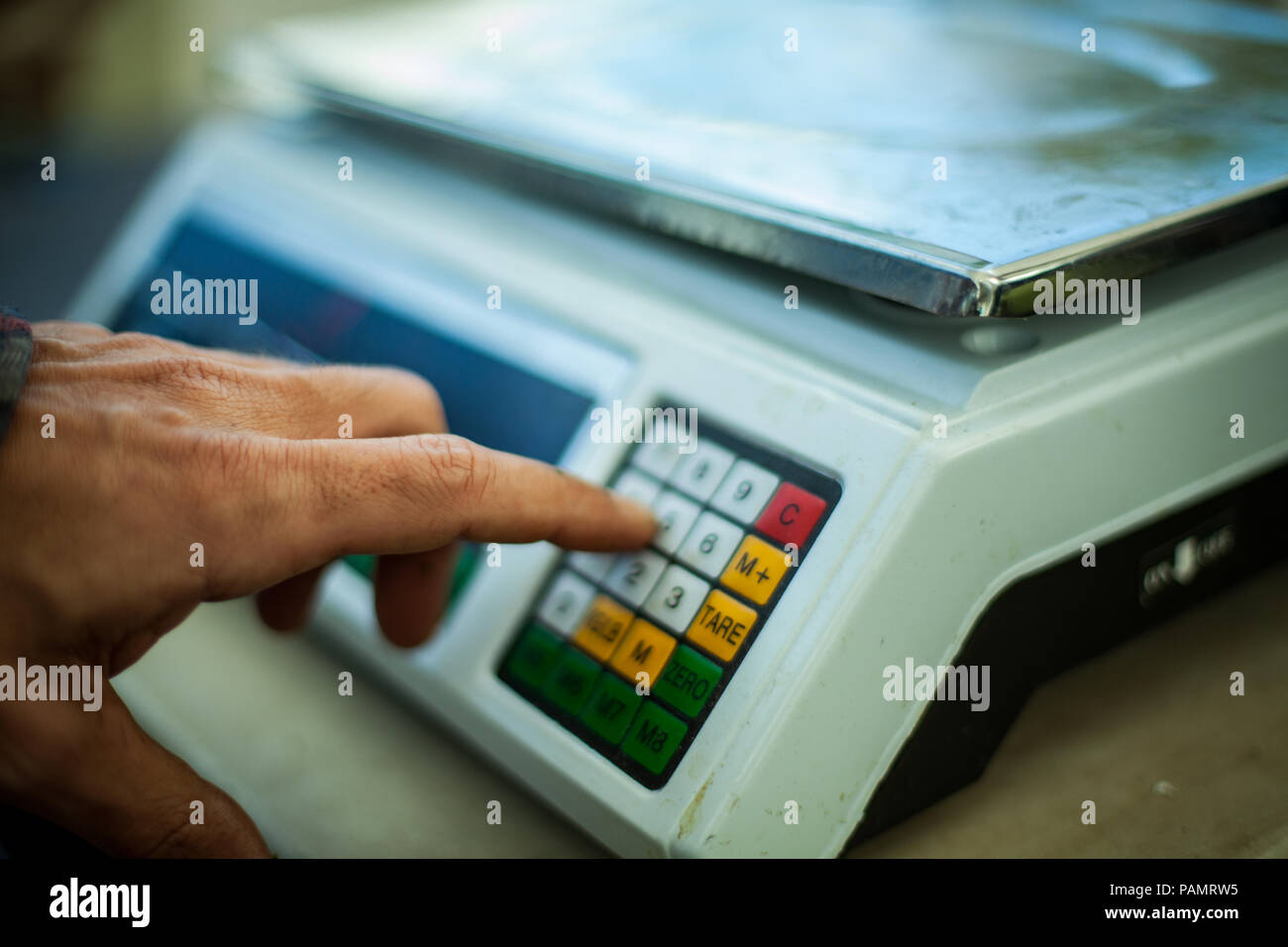 Hand pressing the balance buttons at farmer's market Stock Photo - Alamy