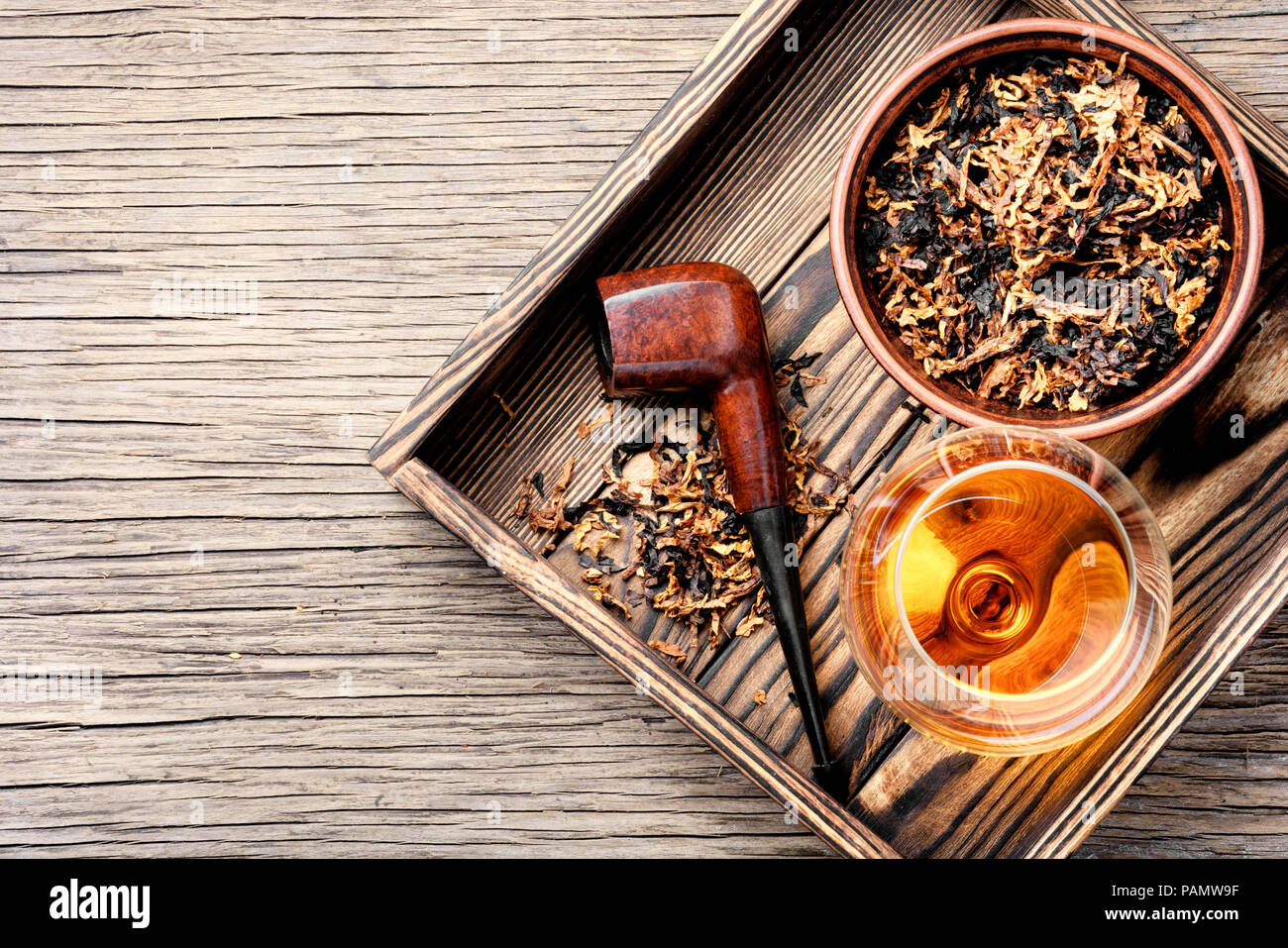 Glass of cognac and pipe with tobacco Stock Photo - Alamy