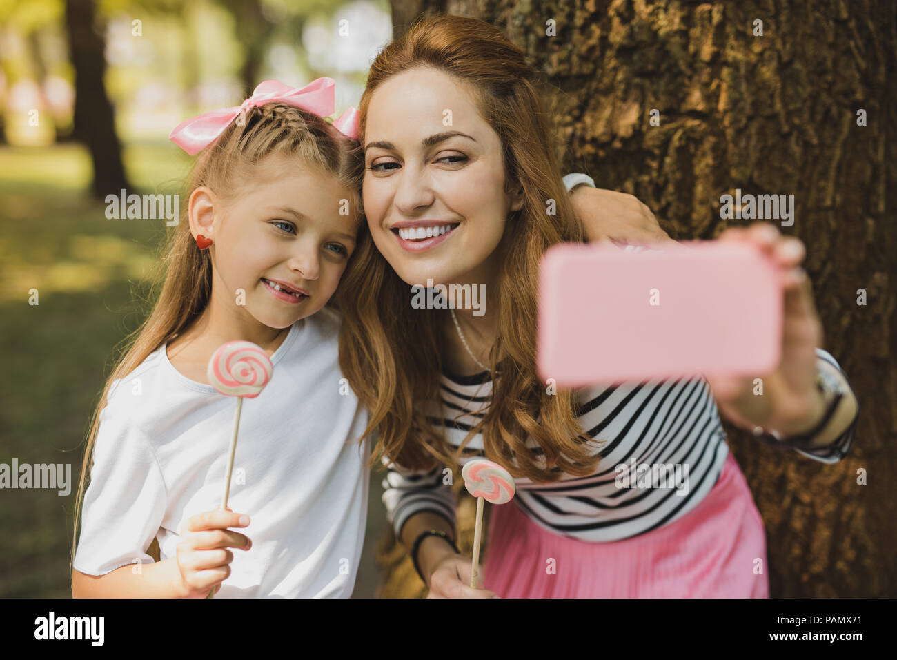 Little modern girl posing for photo with her loving mother Stock Photo ...