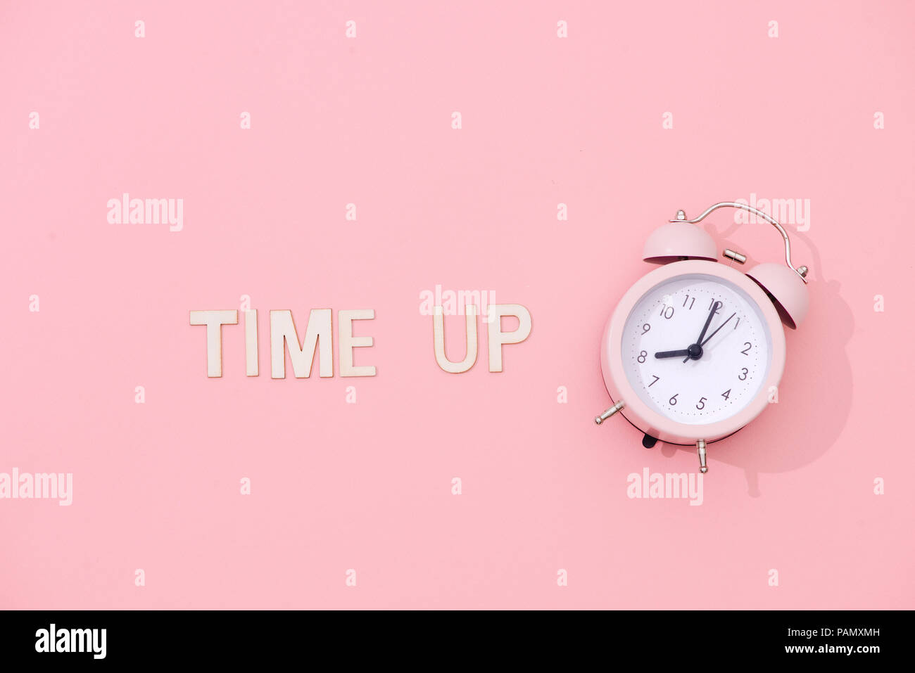 TIME UP text with light pink retro alarm clock with shadow on pink ...