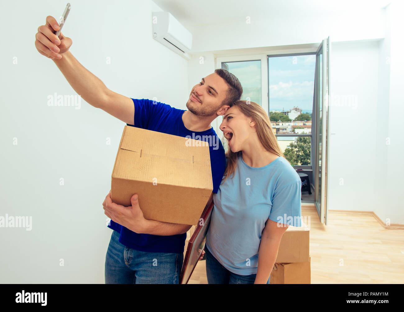Handsome man make selfie with cell phone while holding cardboard box in ...