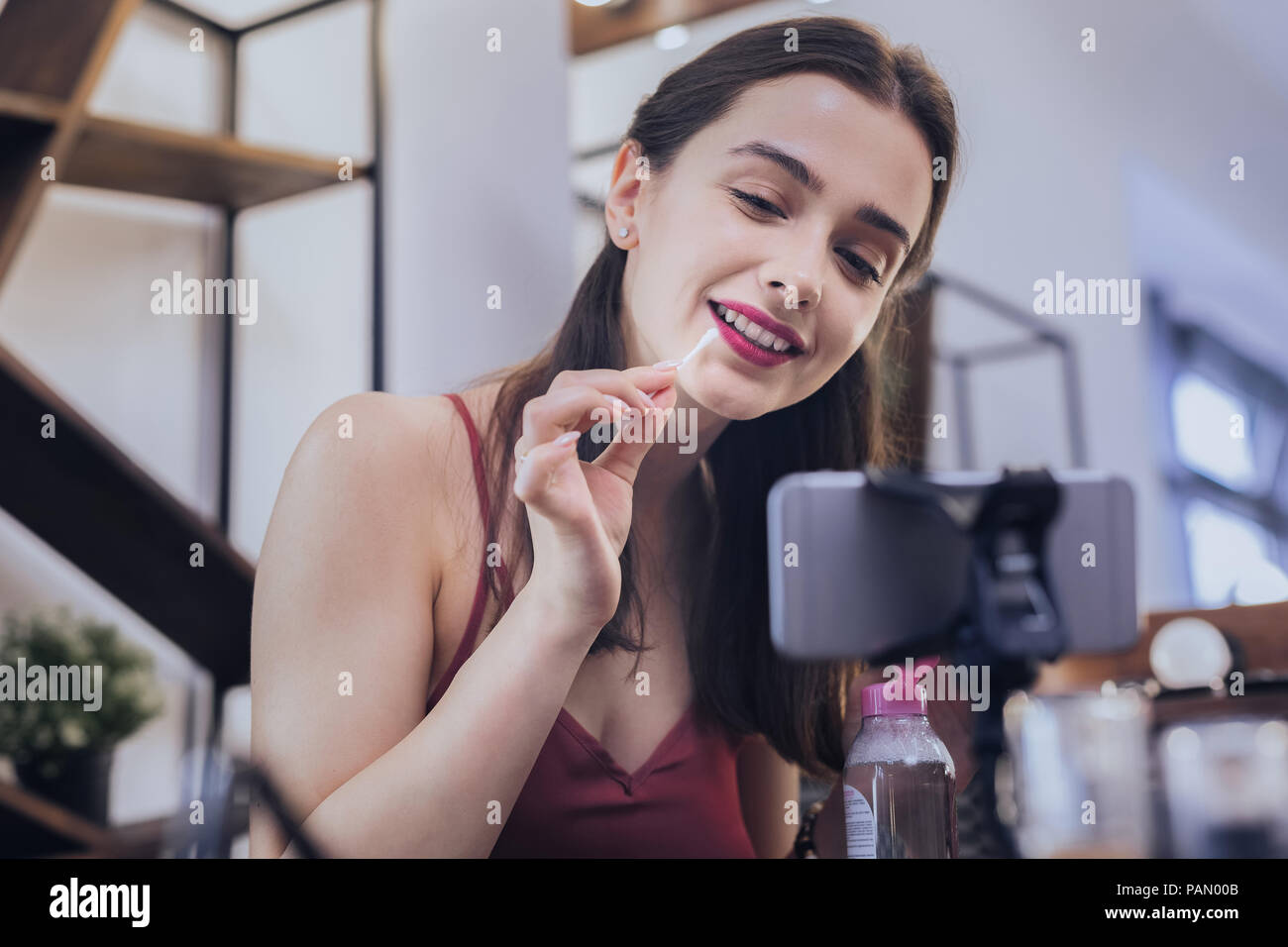 Dark-haired cheerful woman fixing her makeup Stock Photo - Alamy