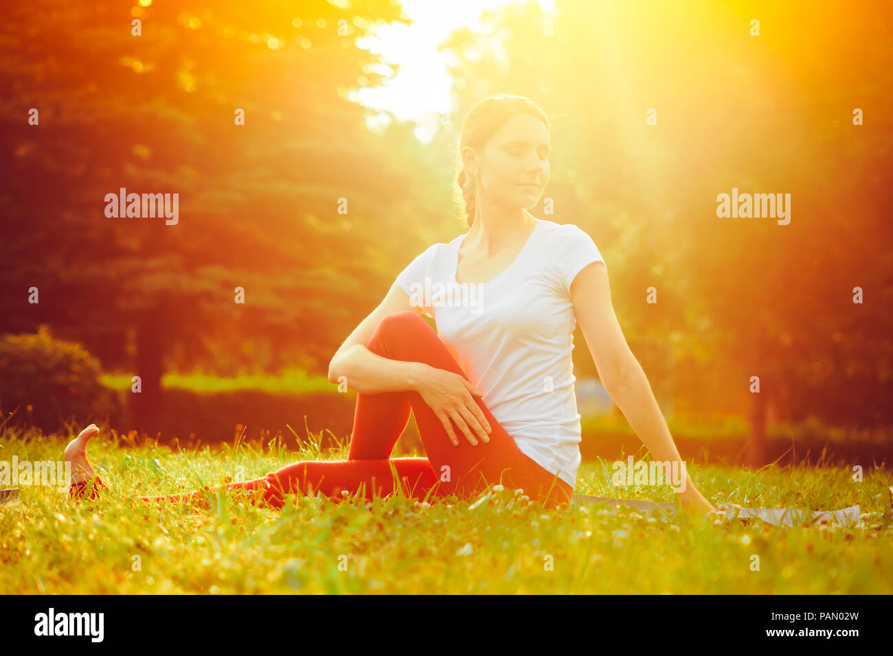 Pretty woman doing yoga exercises in the park Stock Photo - Alamy