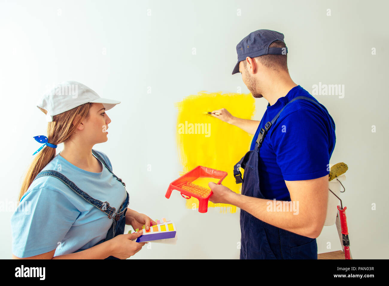 Adorable married couple doing home makeover with yellow color Stock ...
