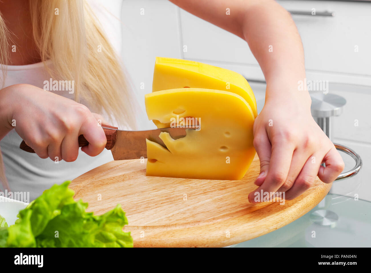 hands of a young woman eating cheese at home in the kitchen Stock Photo ...