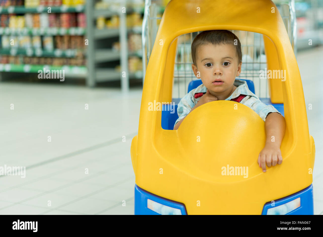 Cute little 2 year old baby boy child in the little toy-car trolley at ...