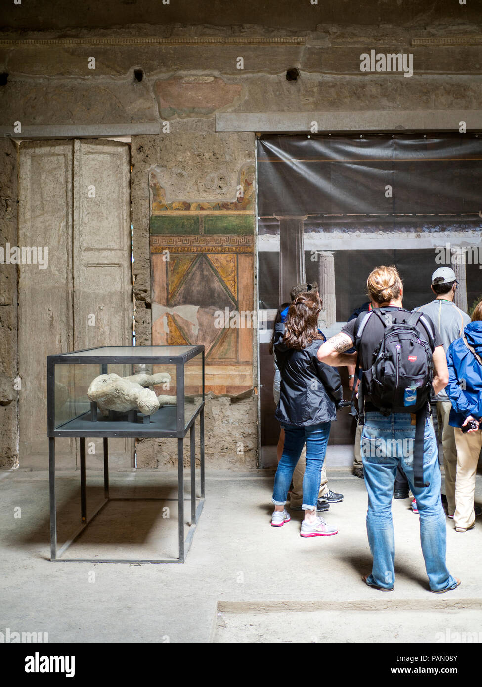 A tourist look at petrified human bodies inside the Villa of Mysteries ...