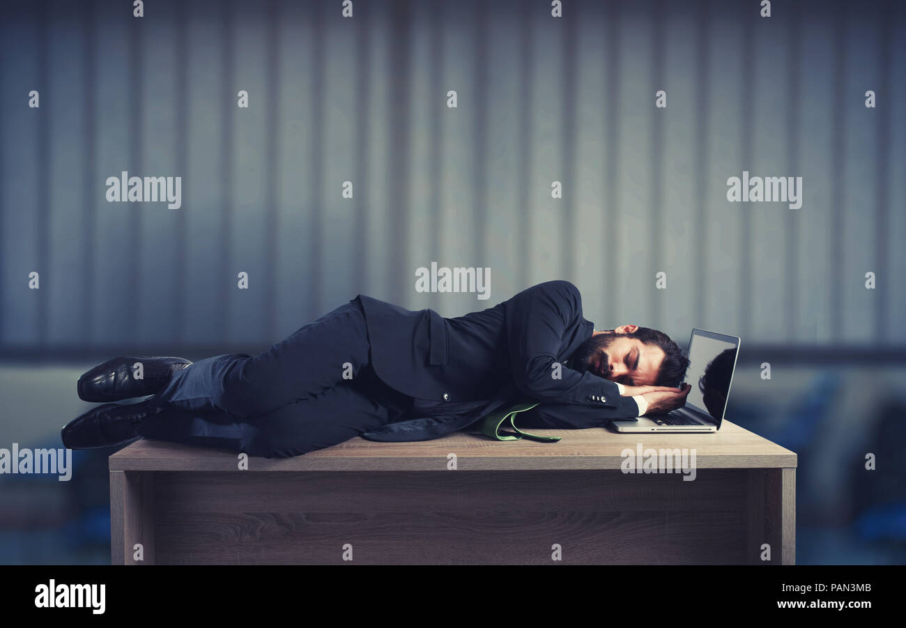 Businessman sleeping over a desk due to overwork Stock Photo - Alamy