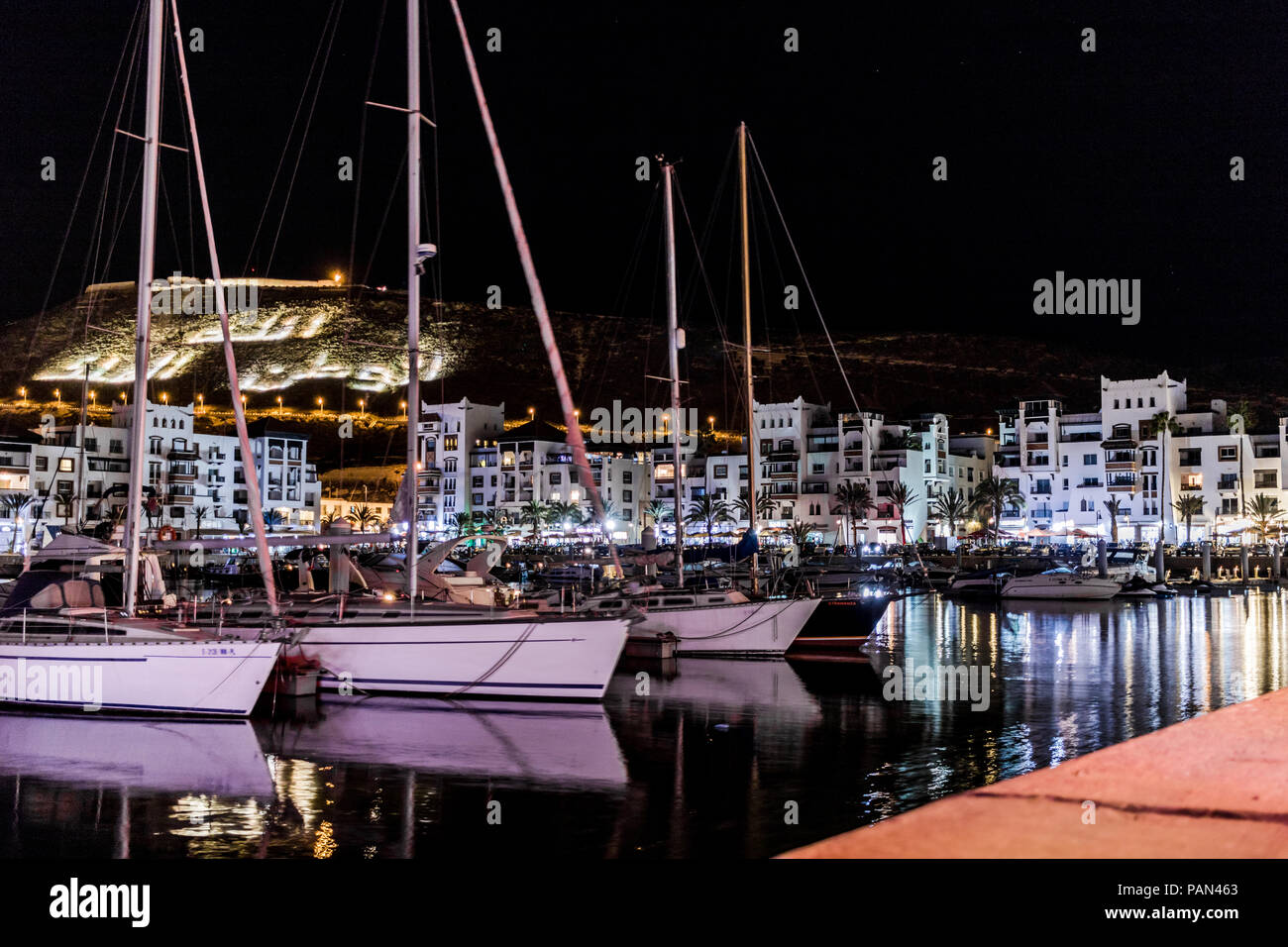 Night photo of the marina and the old kasbah of agadir with boats and ...