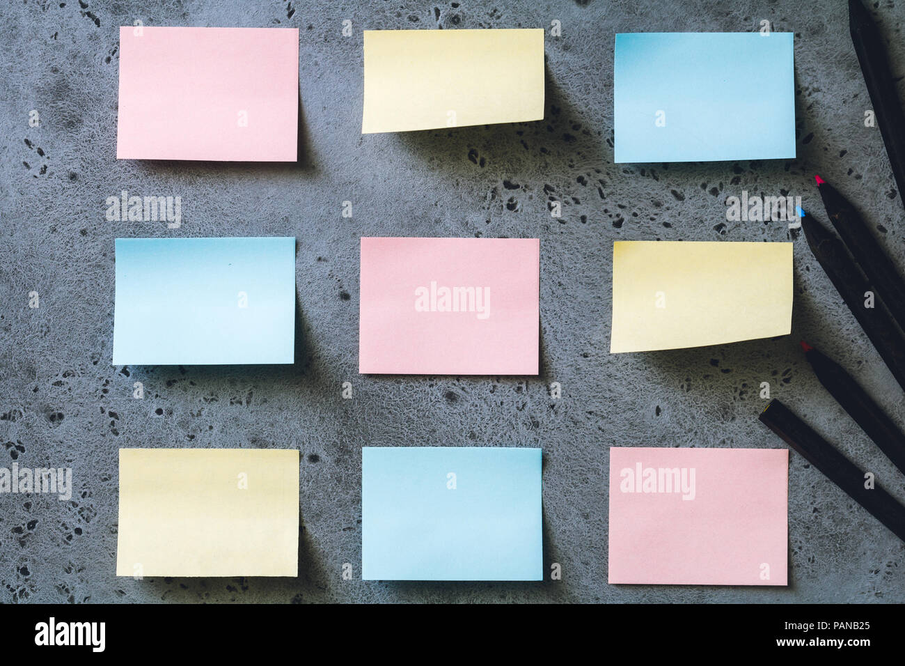 Colorful empty sticky notes on a grey textured background. The concept ...