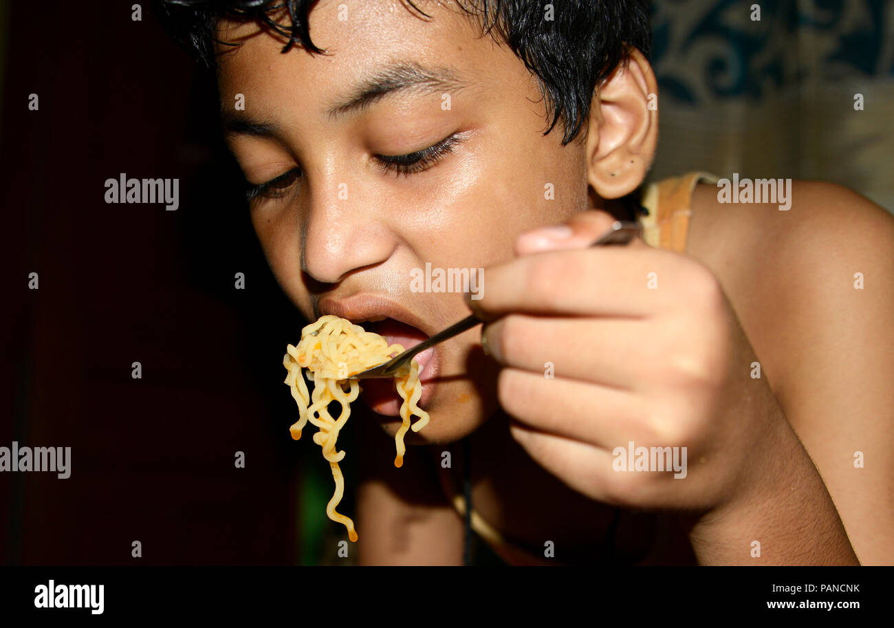 Boy eating Noodles Stock Photo - Alamy