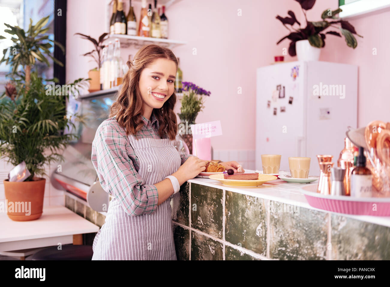 Smiling beaming coffee room worker taking desserts and coffee Stock ...