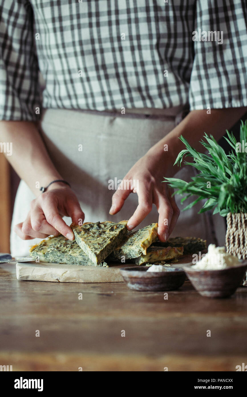 Young woman garnishing homemade chickpea and herb cake Stock Photo - Alamy