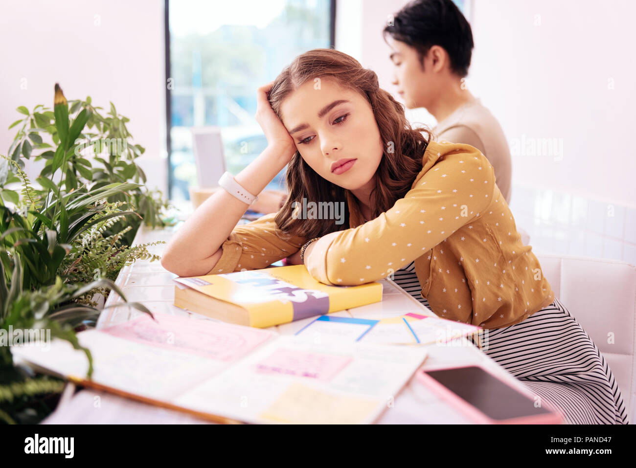 Beautiful student feeling tired after studying all day Stock Photo - Alamy