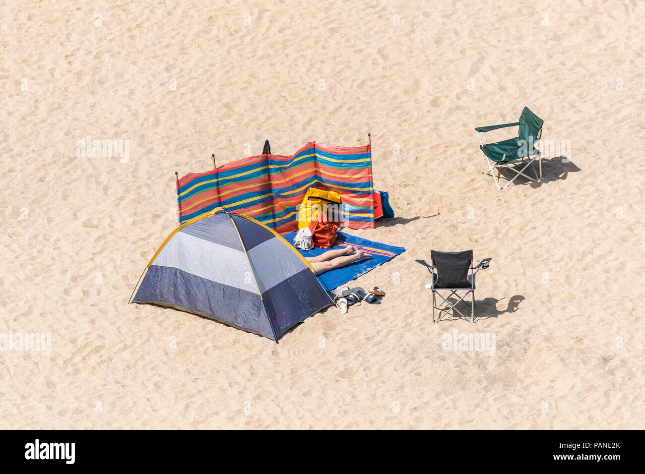 A shelter and a windbreak around a person holidaymaker sunbathing on ...